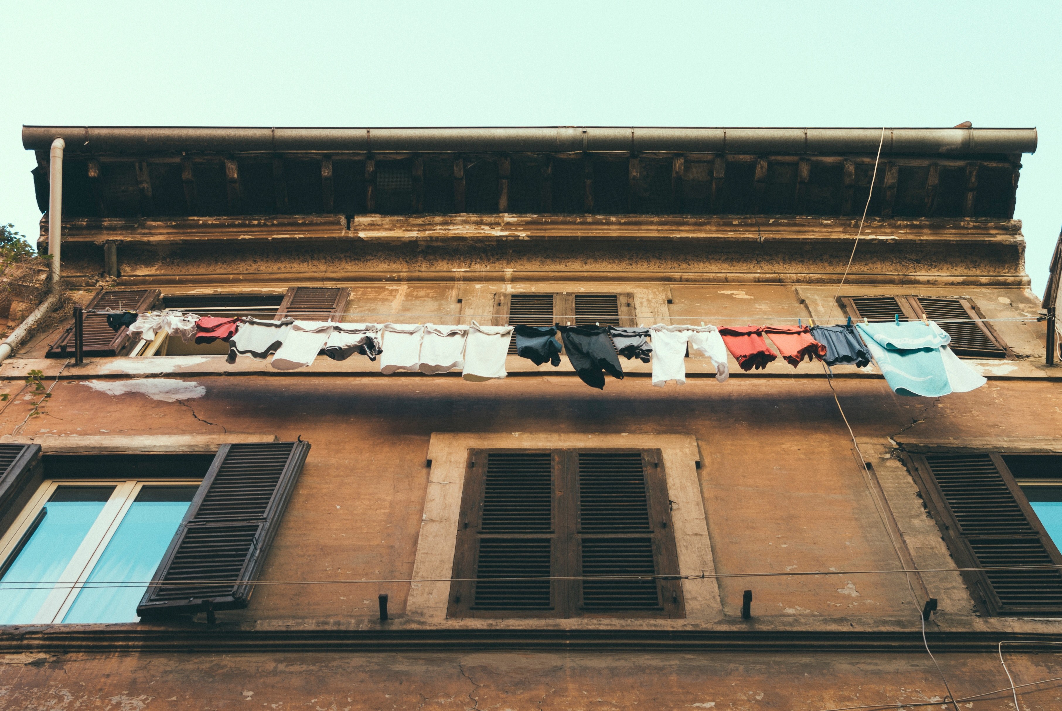 clothes are drying on a long clothesline at an old building with wooden ...