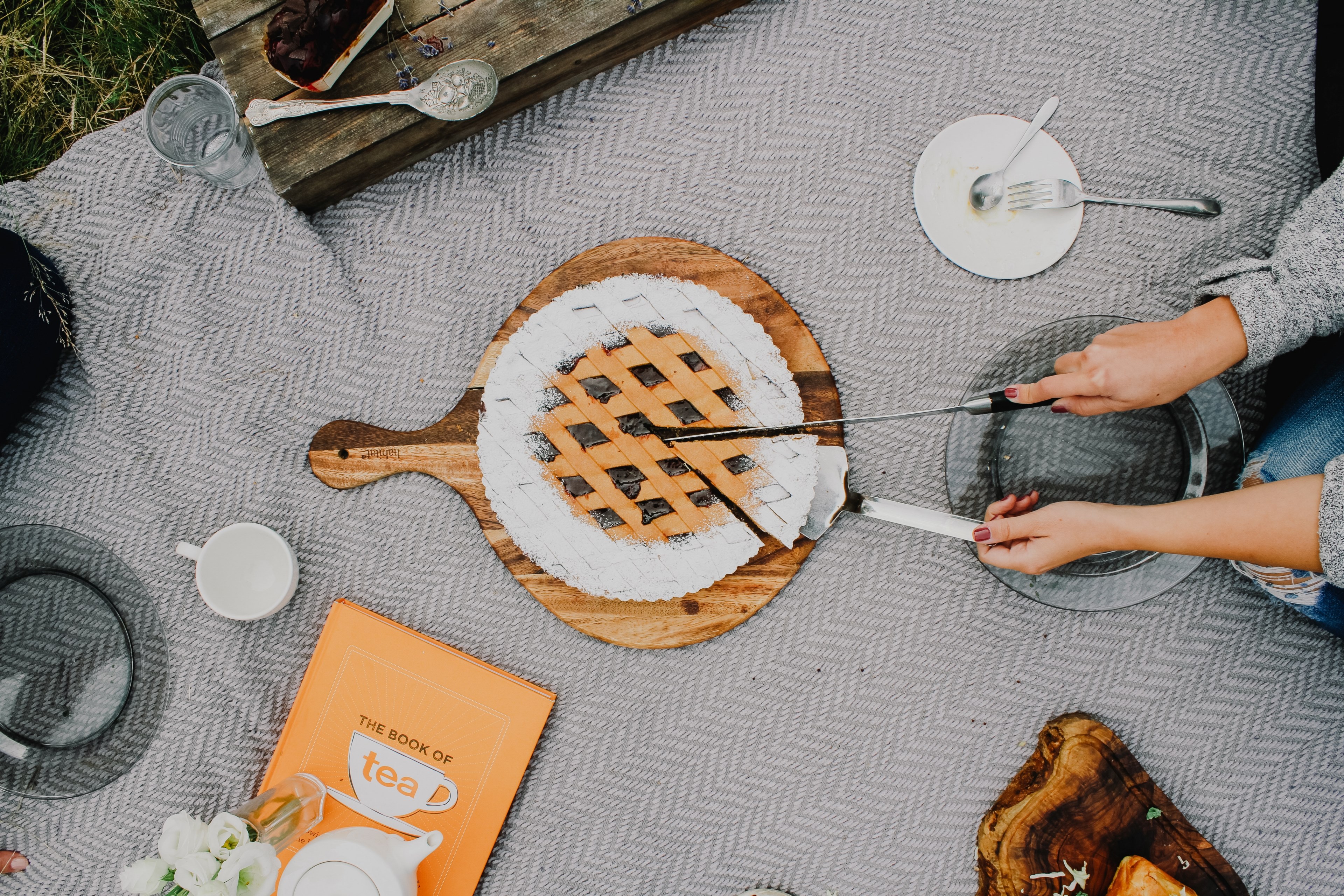 friends slice a piece of pie at a picnic in the park, sharing is caring ...