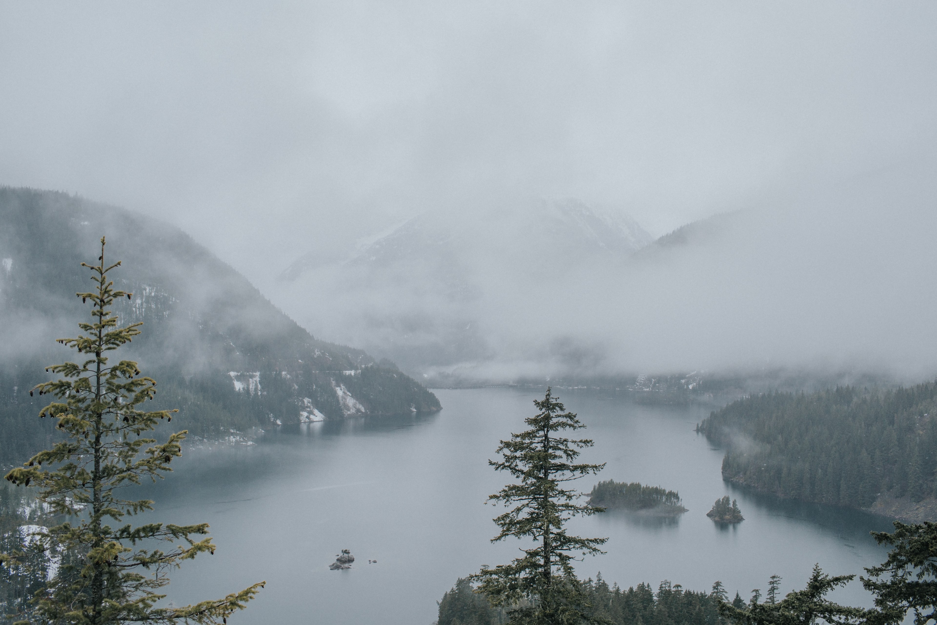 fog rolls in over calm waters on a misty morning in diablo lake, mist ...