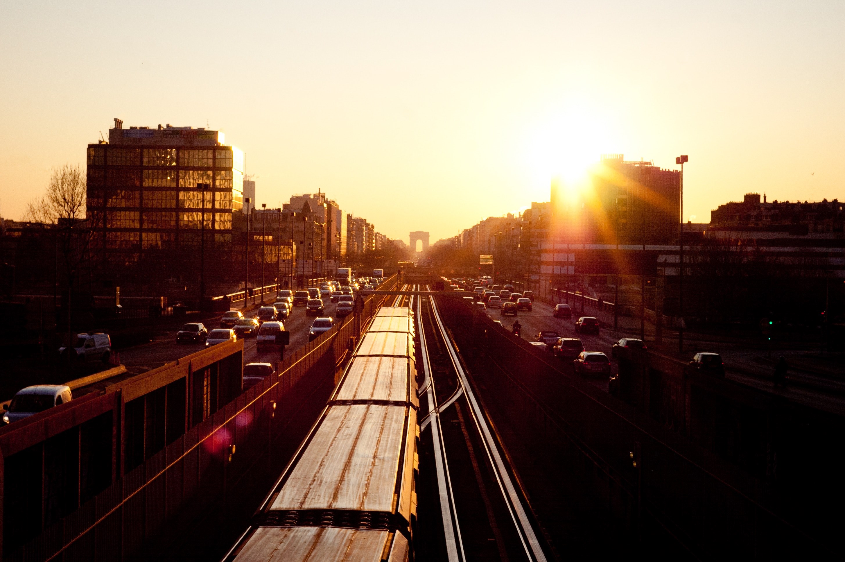 sunset shines over busy freeway as traffic flows through lanes, busy ...